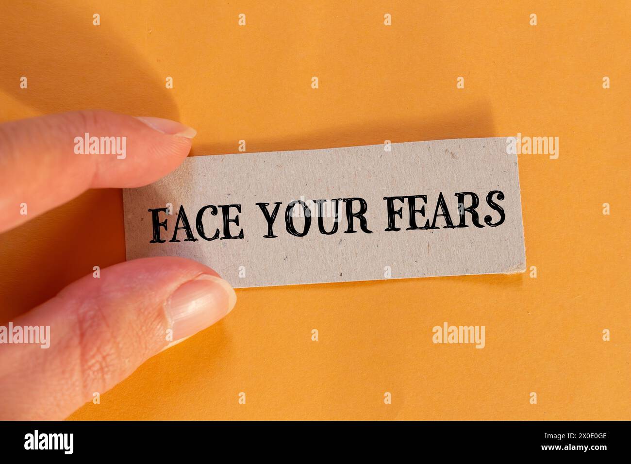 Face your fears words written on paper piece with orange background ...