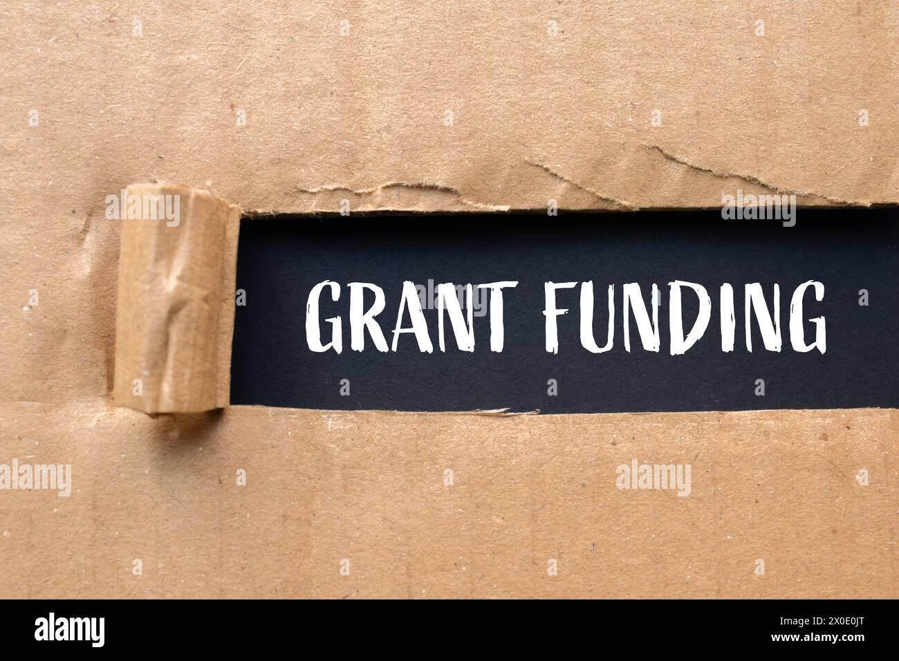 Grant funding words written on ripped cardboard paper with black ...