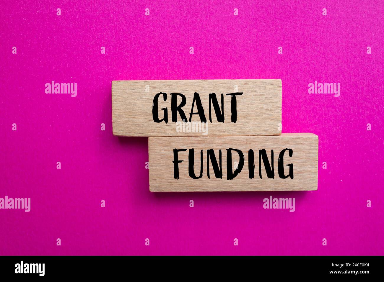 Grant funding words written on wooden blocks with pink background ...