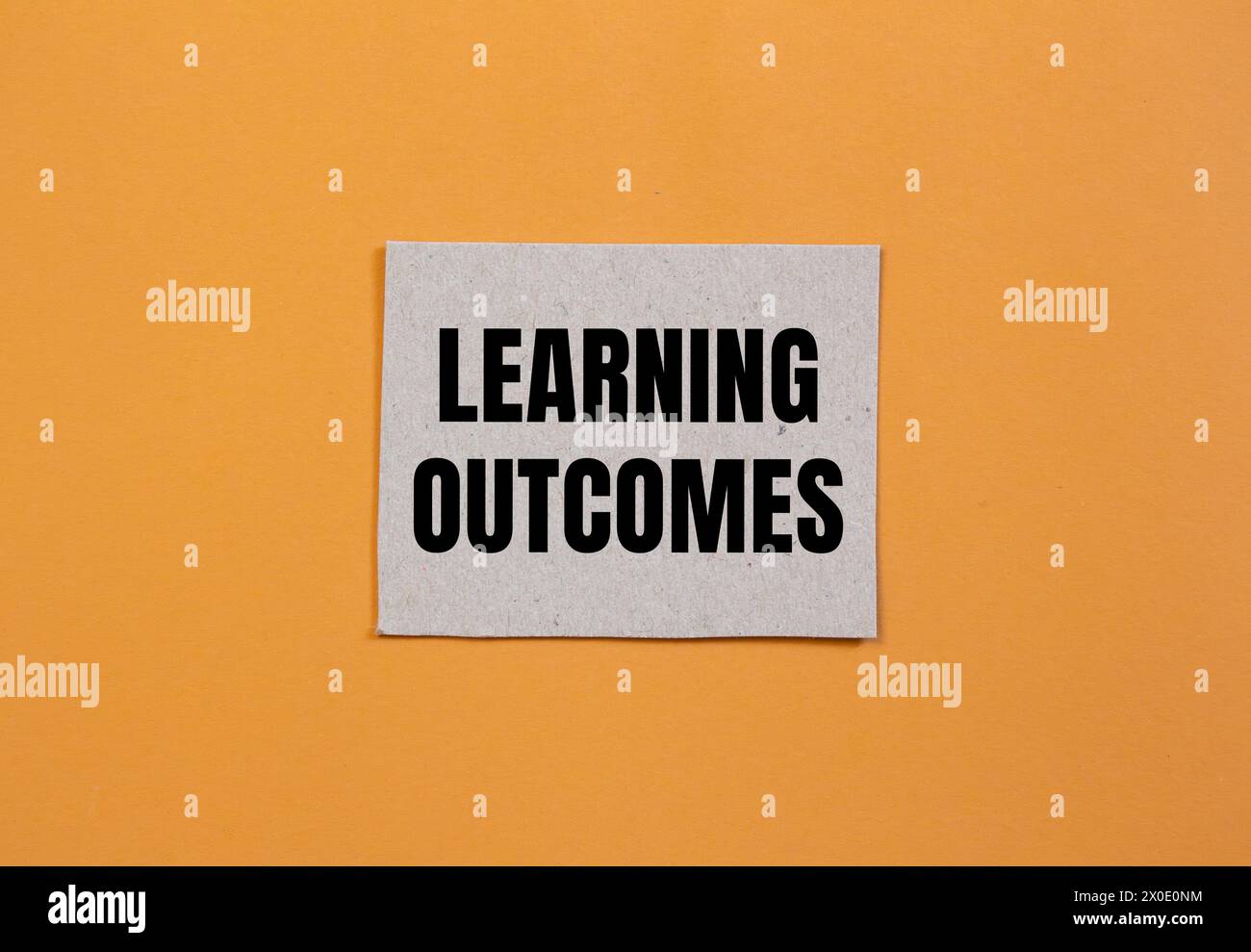 Learning outcomes words written on paper pieces with orange background ...