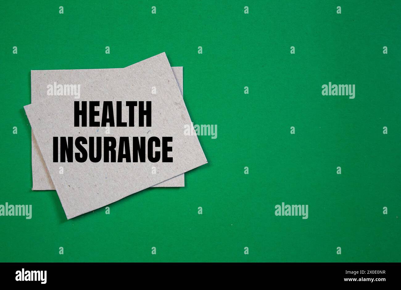 Health insurance words written on ripped paper with green background ...