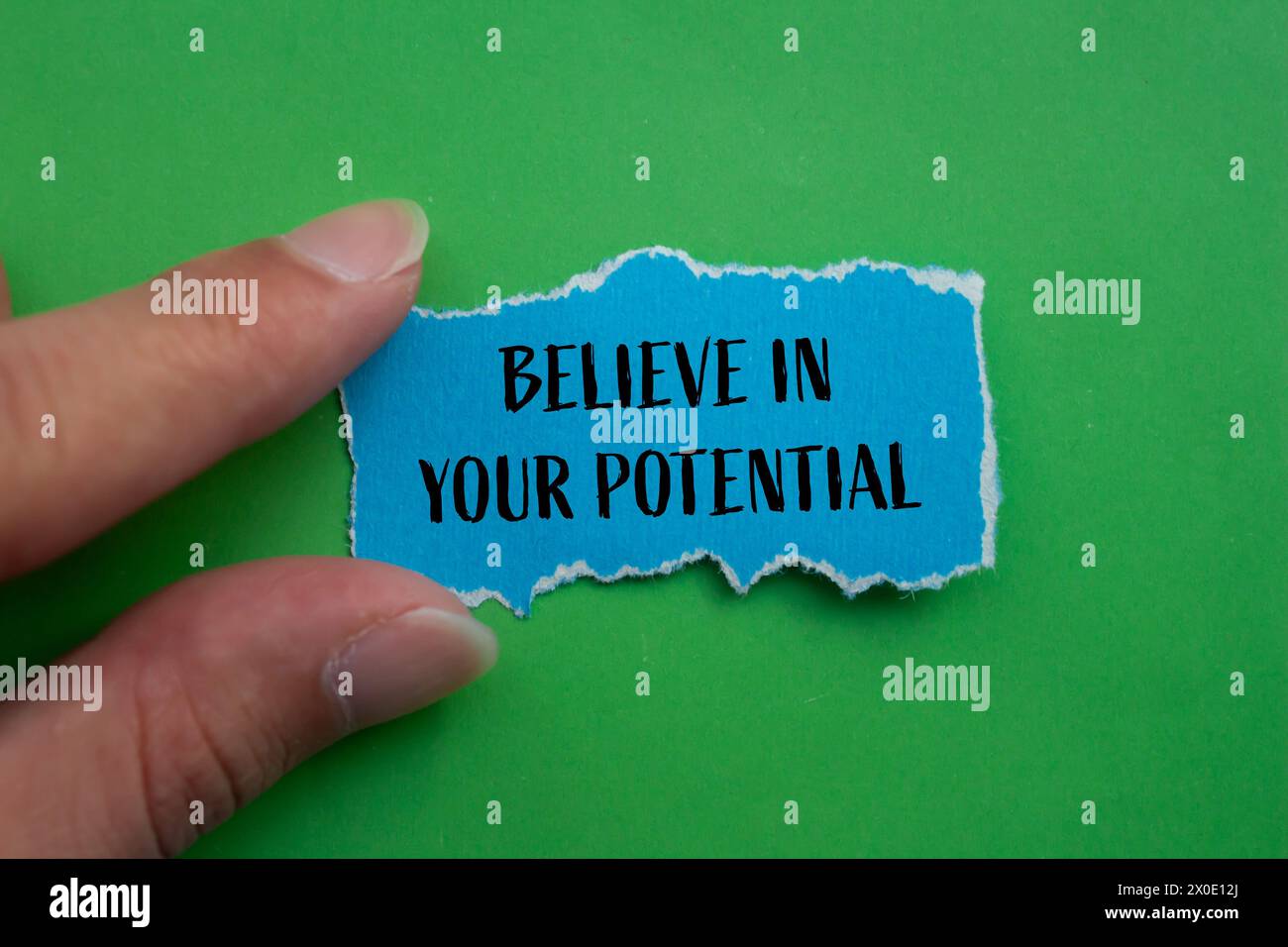 Believe in your potential words written on ripped paper with green ...