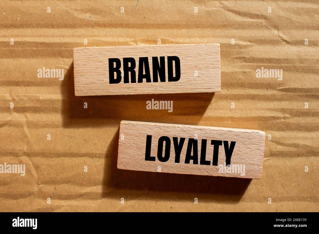 Brand loyalty words written on wooden blocks with cardboard background ...