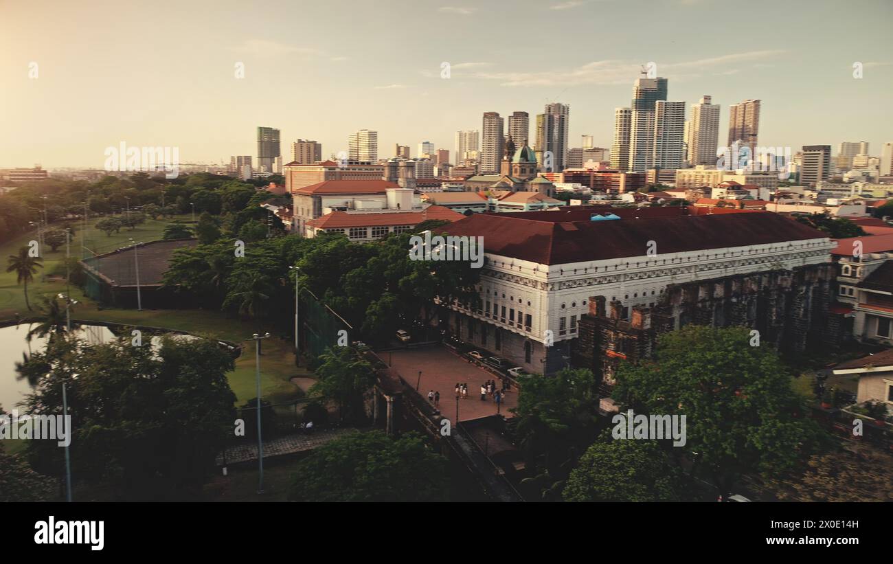 Modern building at green trees tops aerial. Sun shine over skyscrapers ...