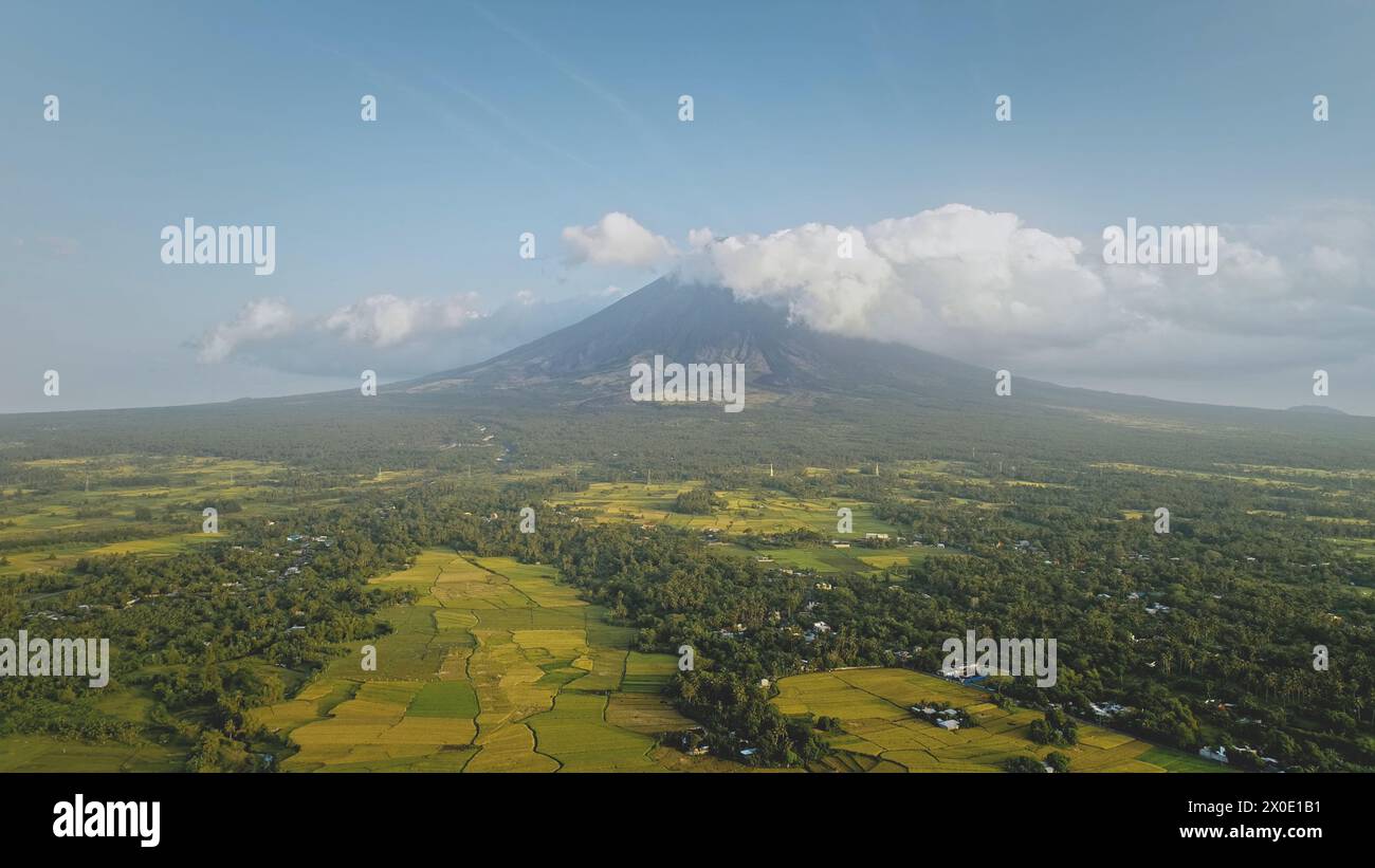 Aerial view of Mayon volcano eruption at green valley. Rural fields at ...