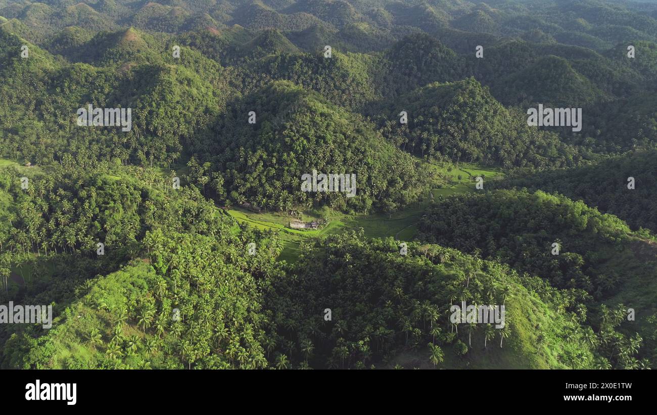 Philippines green jungle mountains aerial view. Small farm building at ...