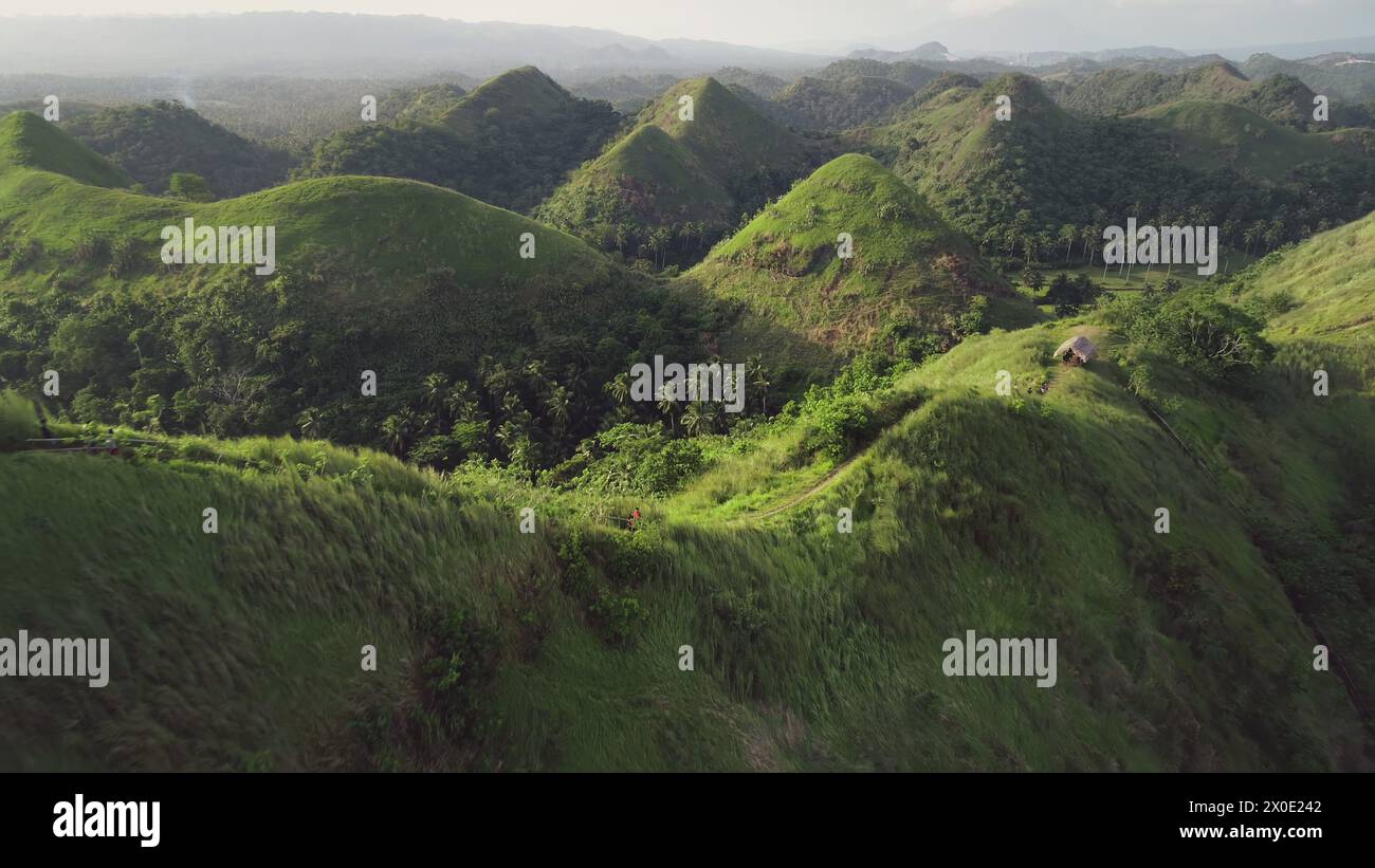 Timelapse green grass hills aerial: building, path at mounts ranges ...