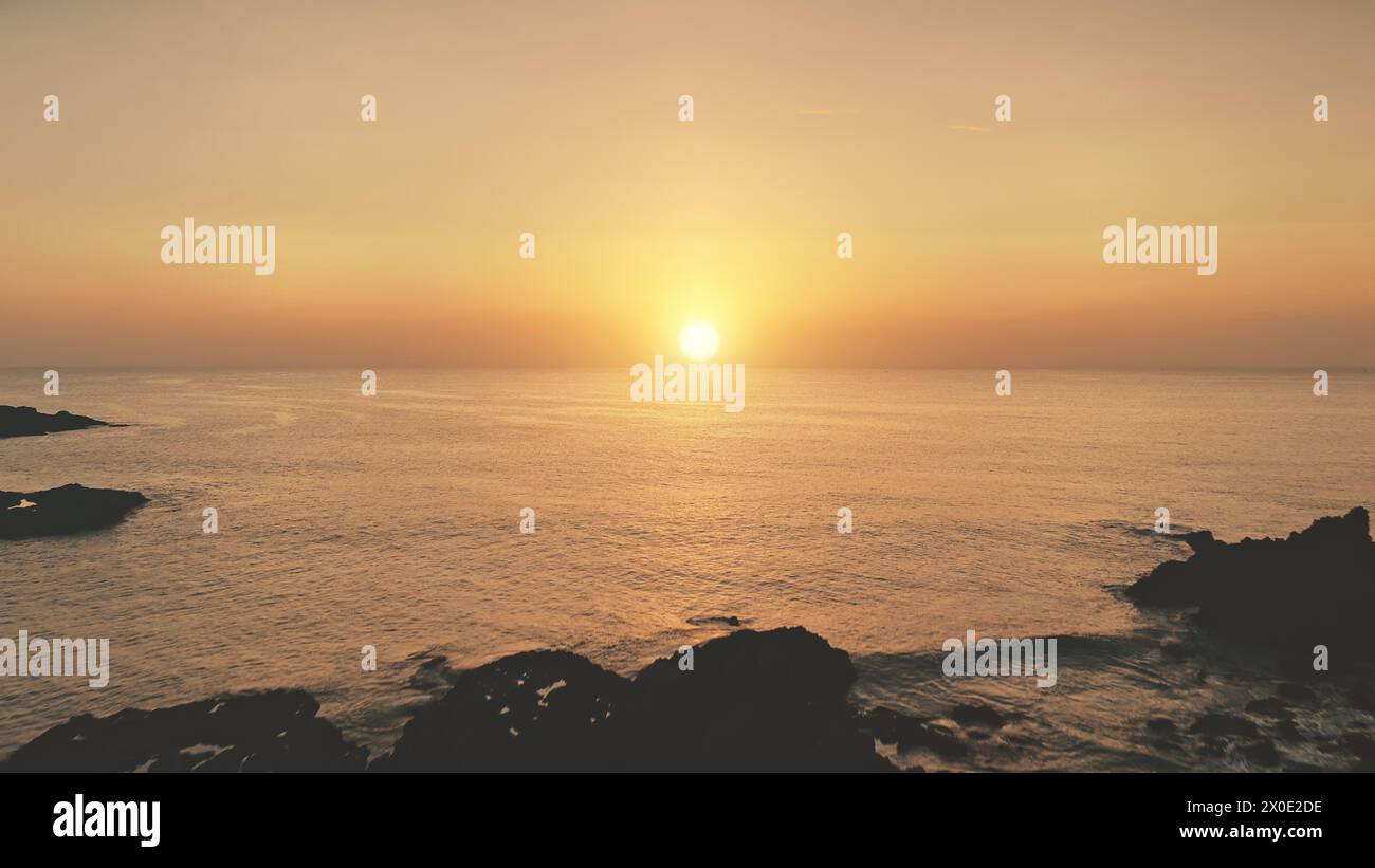 Slow motion sunset seascape at rocks, stones shore aerial. Waves at ...