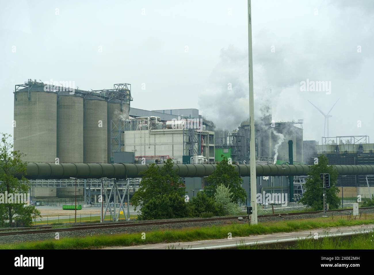 A factory releasing billowing smoke from its tall stacks into the sky ...