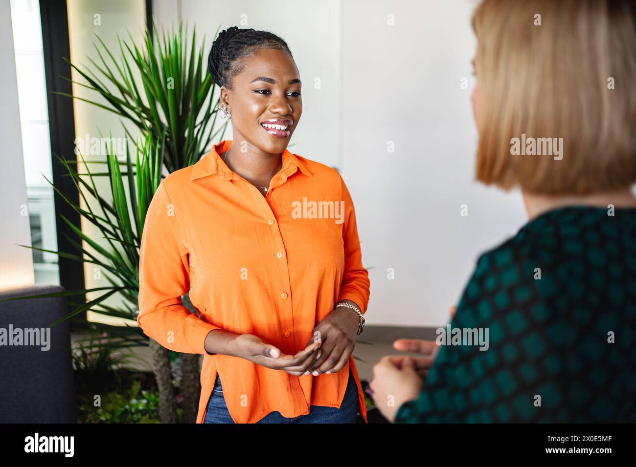 Women Talking in Orange Shirt Stock Photo - Alamy