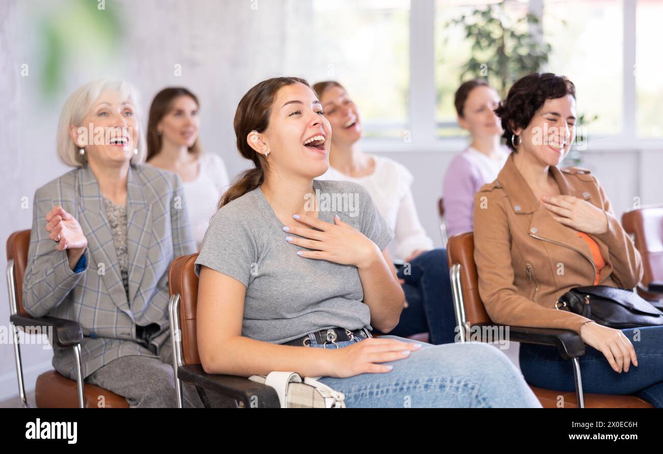 small group of women are sitting in audience, listening to lecture and ...