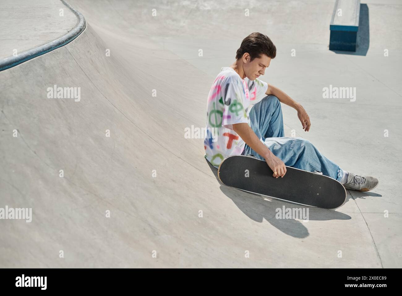 A young man deep in concentration as he sits on his skateboard gliding ...
