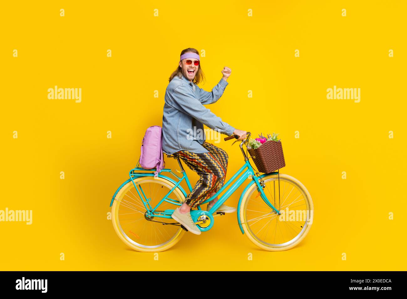 Full body portrait of cool young man ride bike raise fist wear denim ...
