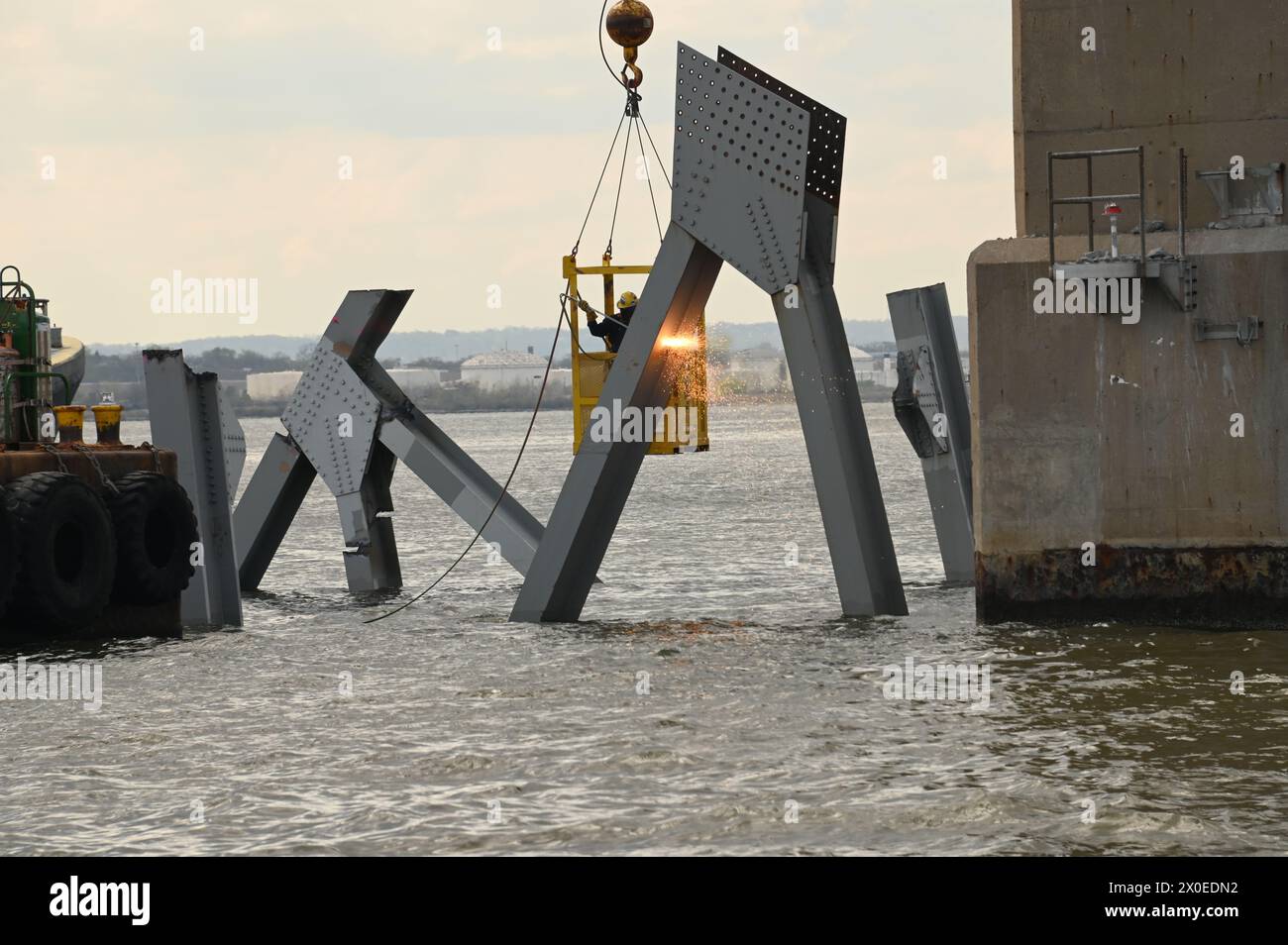 A responder from the Key Bridge Response 2024 cuts through beams from ...