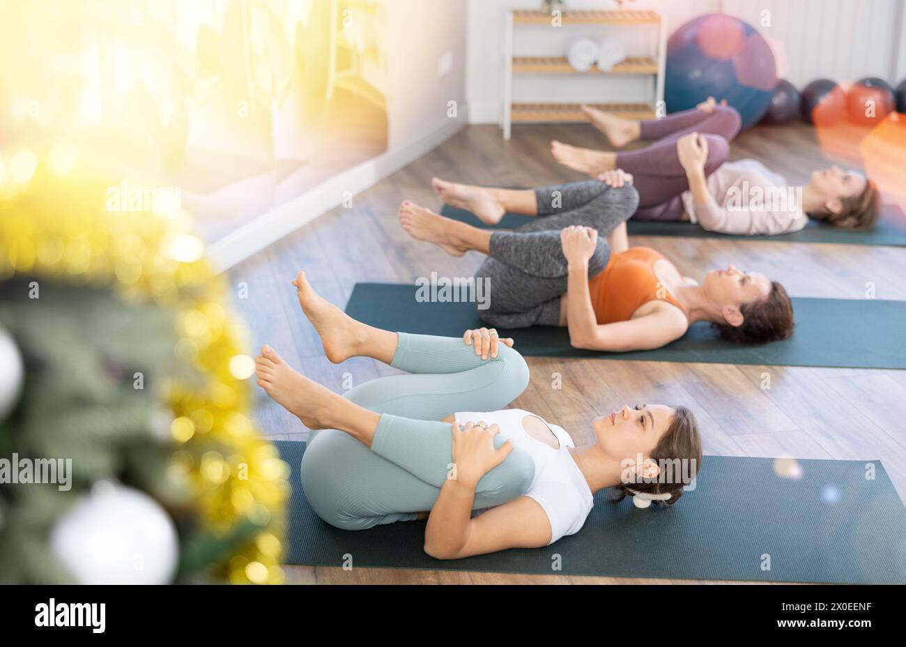 Women practice yoga during the New Year celebration in the studio, lie ...