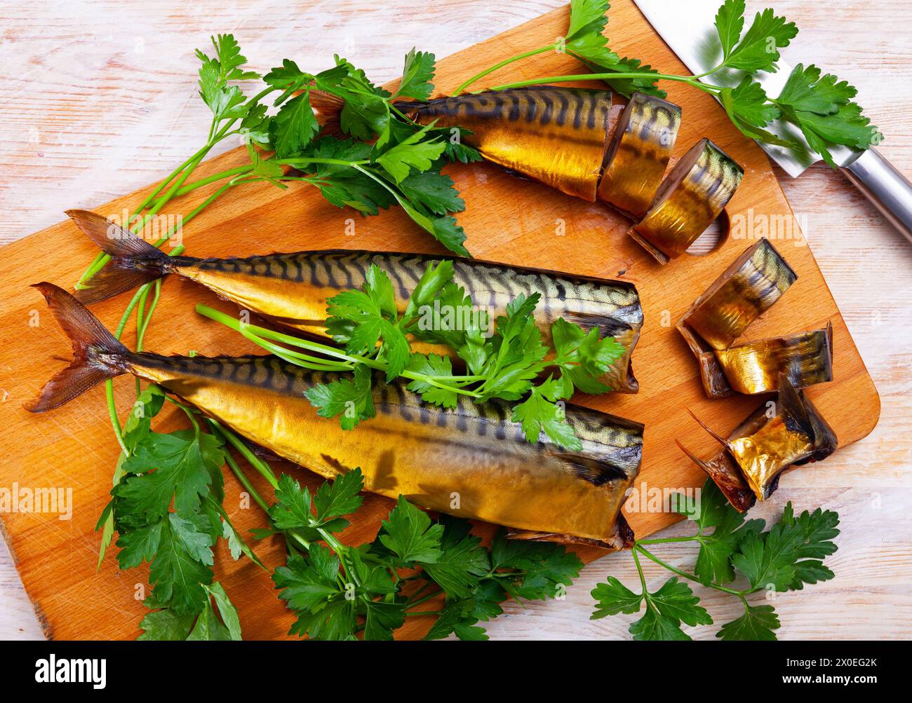 Smoked mackerel cut into pieces with parsley on a table Stock Photo - Alamy