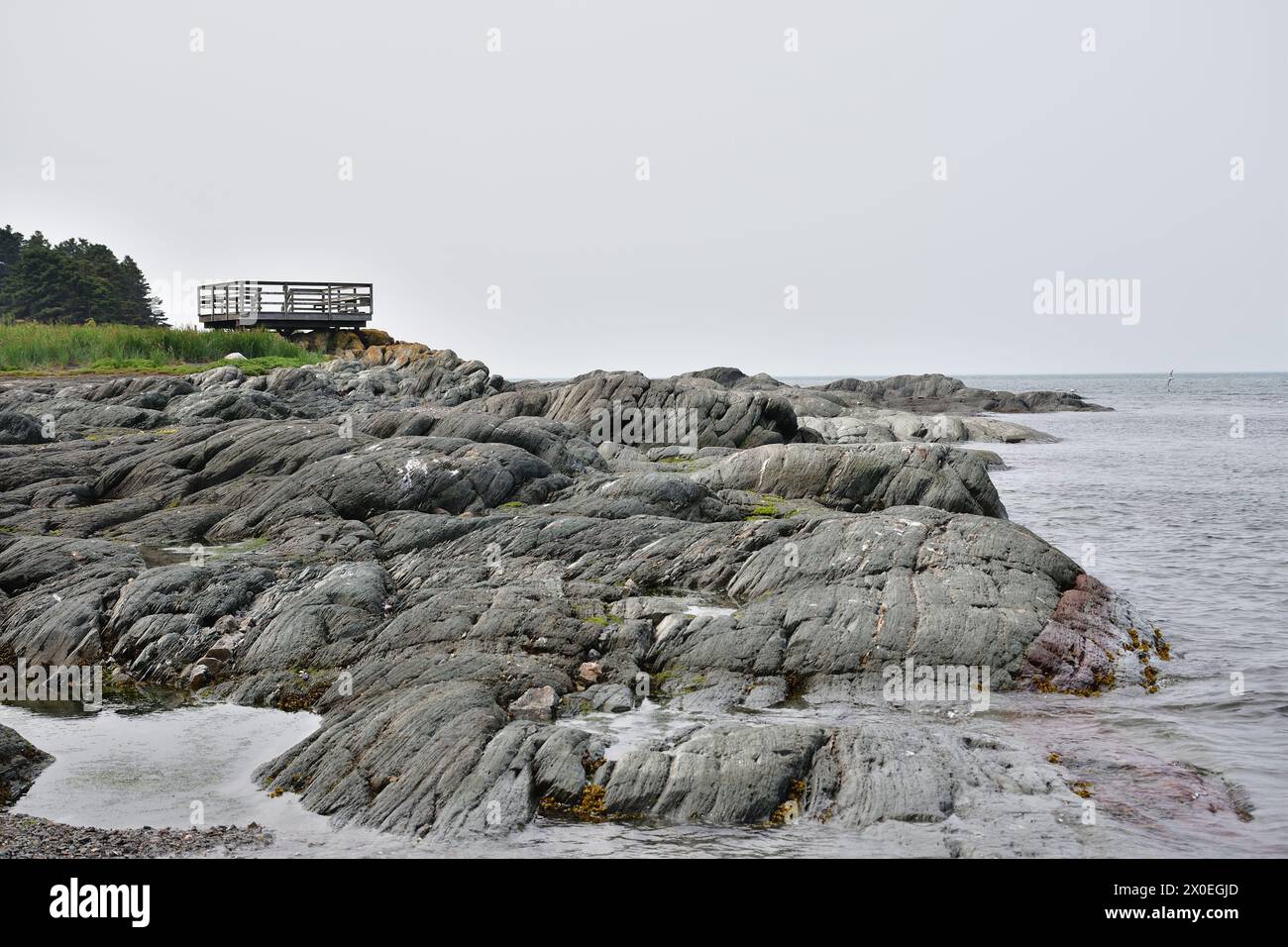 Wooden observatory platform on Island cape. Rocks rounded by the ocean ...