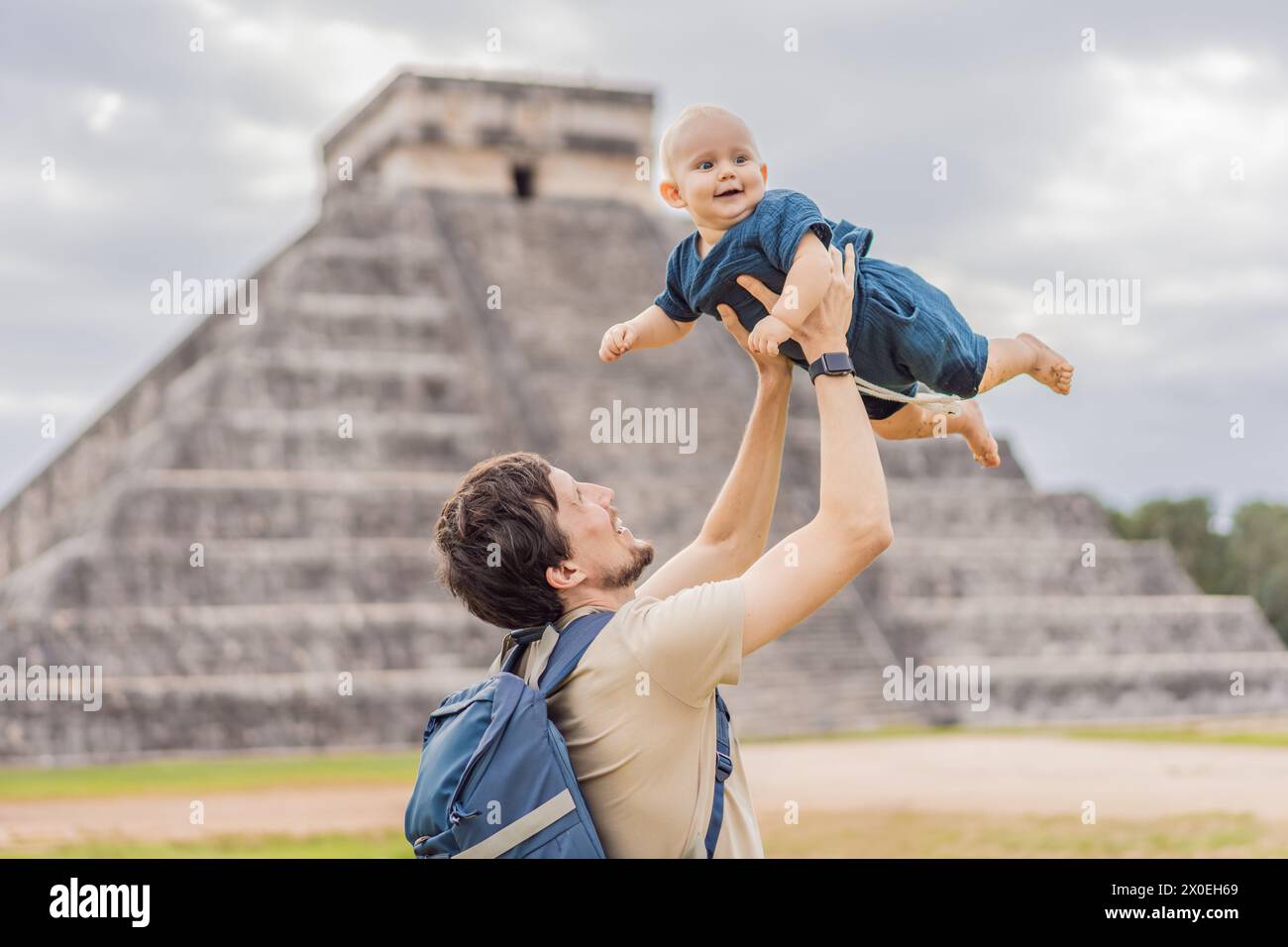 Father and son tourists observing the old pyramid and temple of the ...