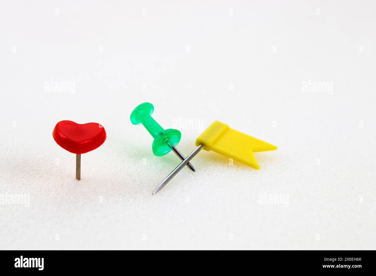 Firm heart shaped thumbtack along with two others of different shapes ...