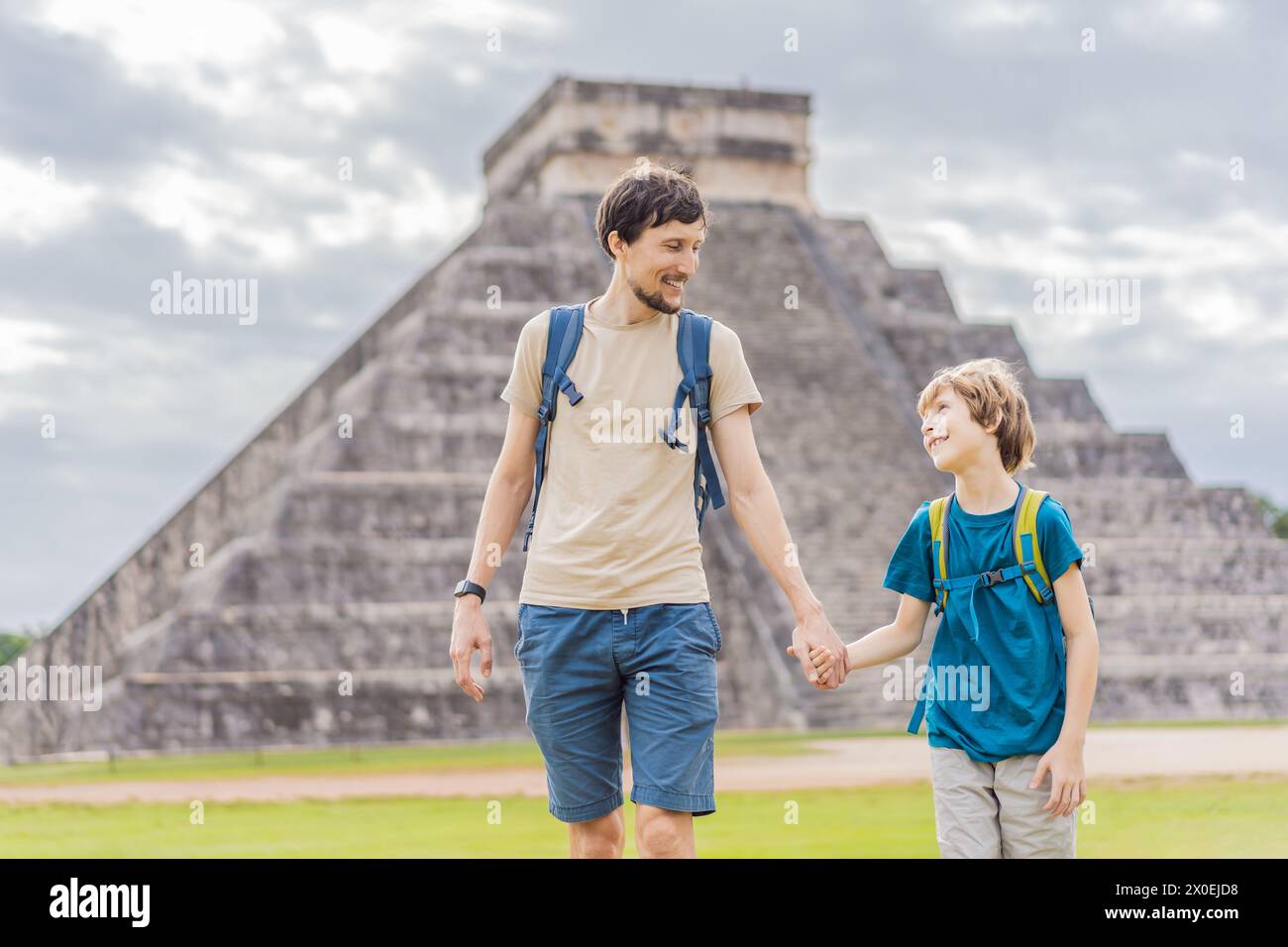 Father and son tourists observing the old pyramid and temple of the ...