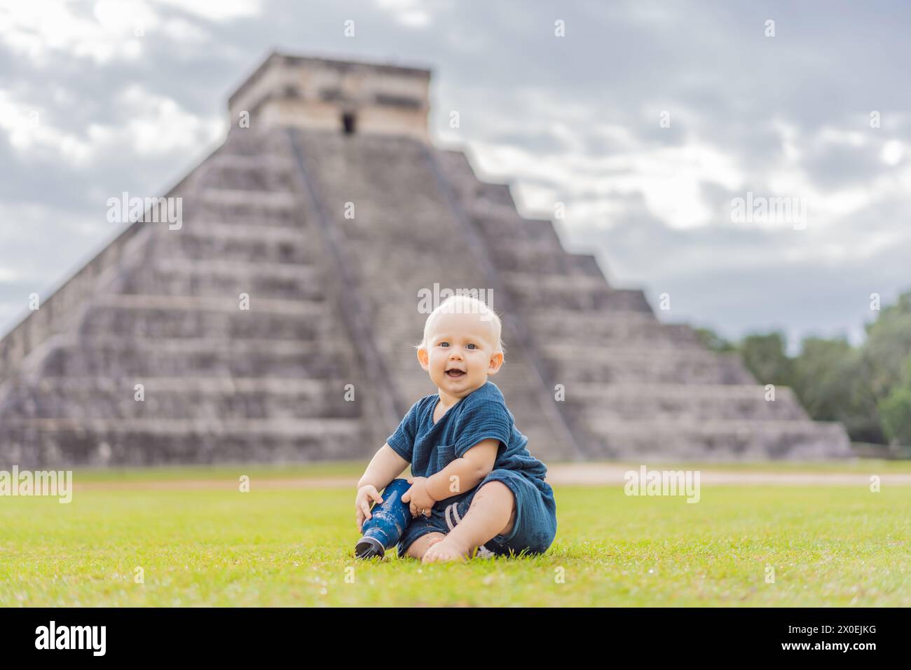 Baby traveler, tourists observing the old pyramid and temple of the ...