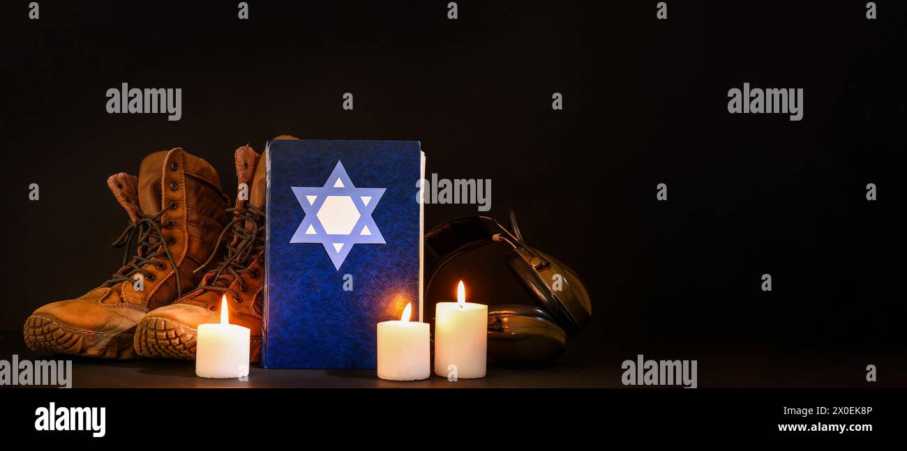 Torah with burning candles and military ammunition on dark background ...