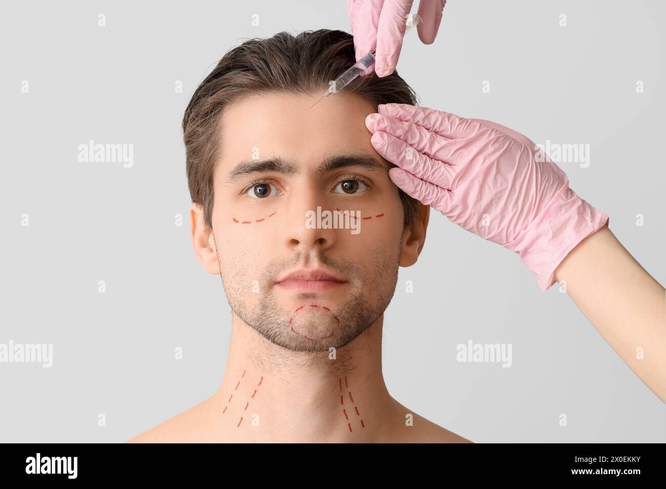 Young man with marked face receiving injection on light background ...