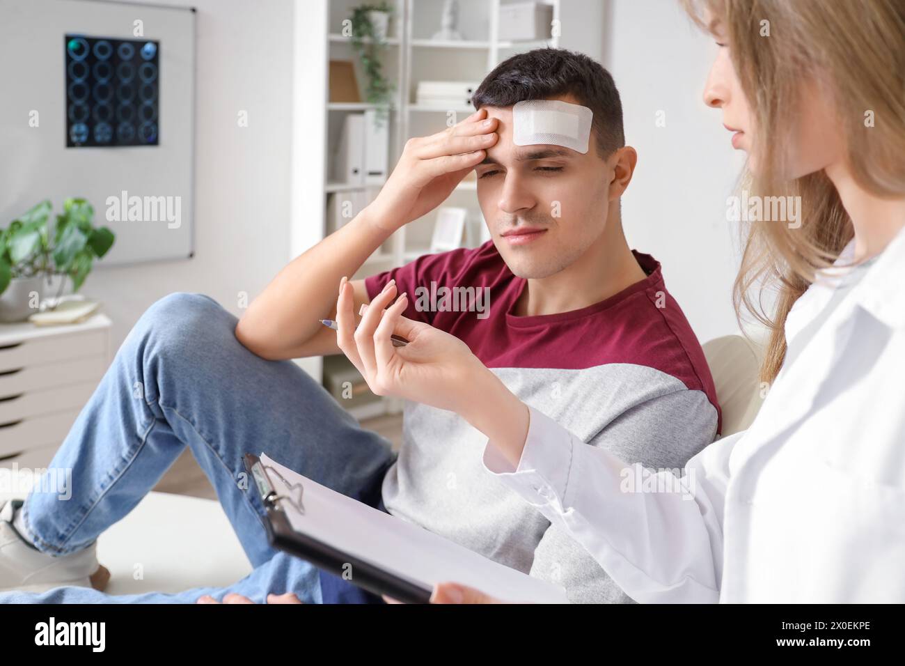 Female doctor examining man with brain concussion in clinic Stock Photo ...