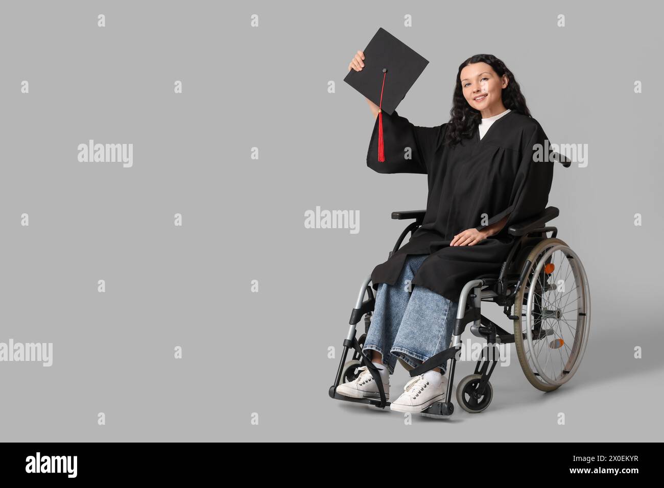 Beautiful female graduate student in wheelchair with graduation cap on ...