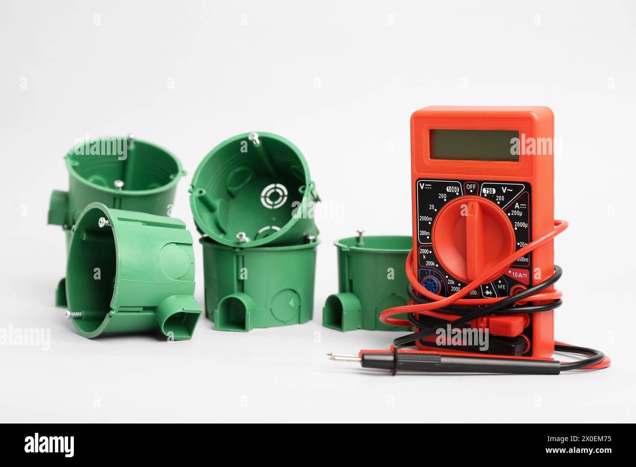 Set of socket boxes and multimeter on light background Stock Photo - Alamy