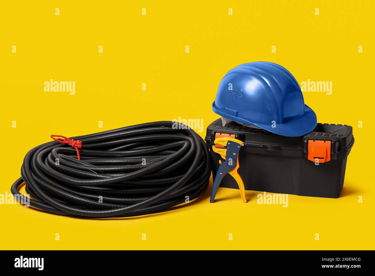 Rolled flexible conduit tube, wire stripper, hardhat and tool box on ...