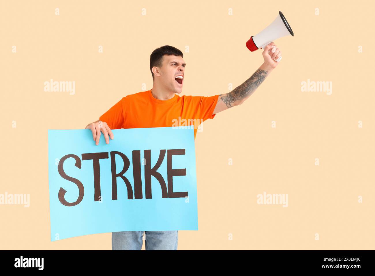 Protesting young man holding placard with word STRIKE and megaphone on ...