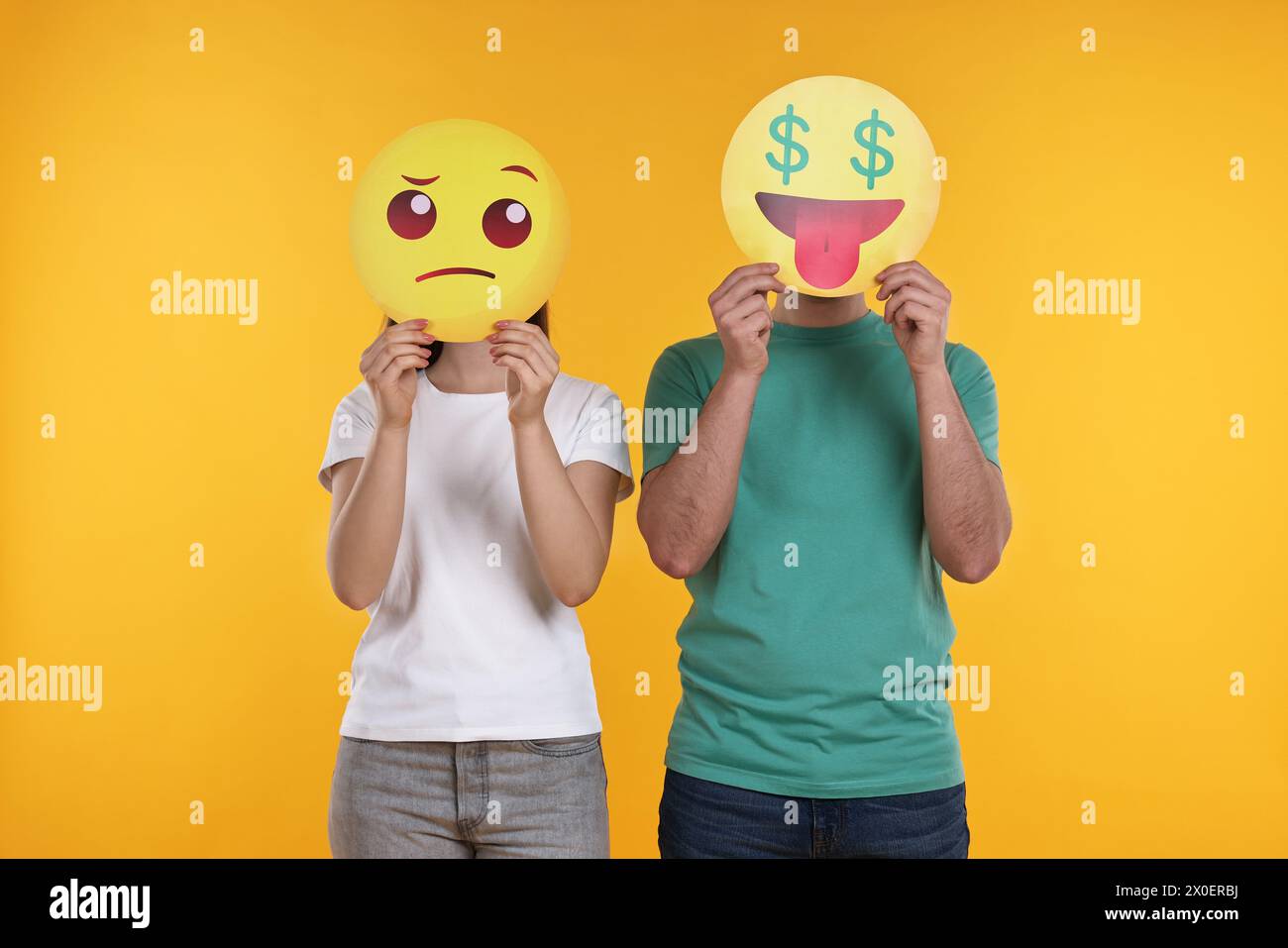 People covering faces with emoticons on yellow background Stock Photo ...