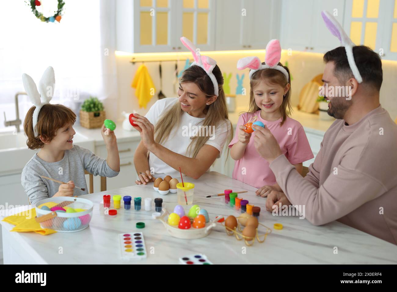 Easter celebration. Happy family with bunny ears having fun while ...