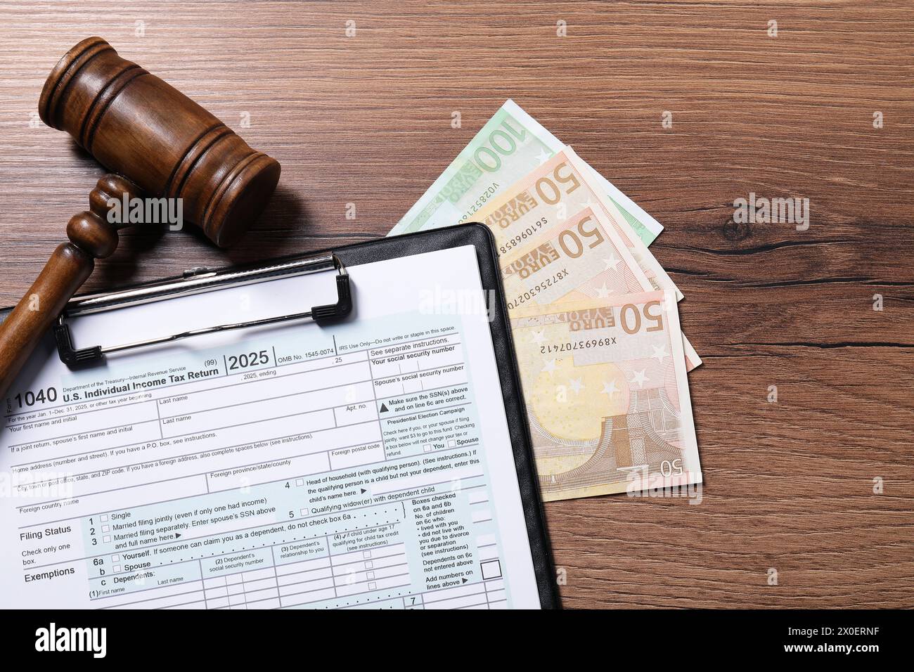 Tax return form, euro banknotes and gavel on wooden table, top view ...