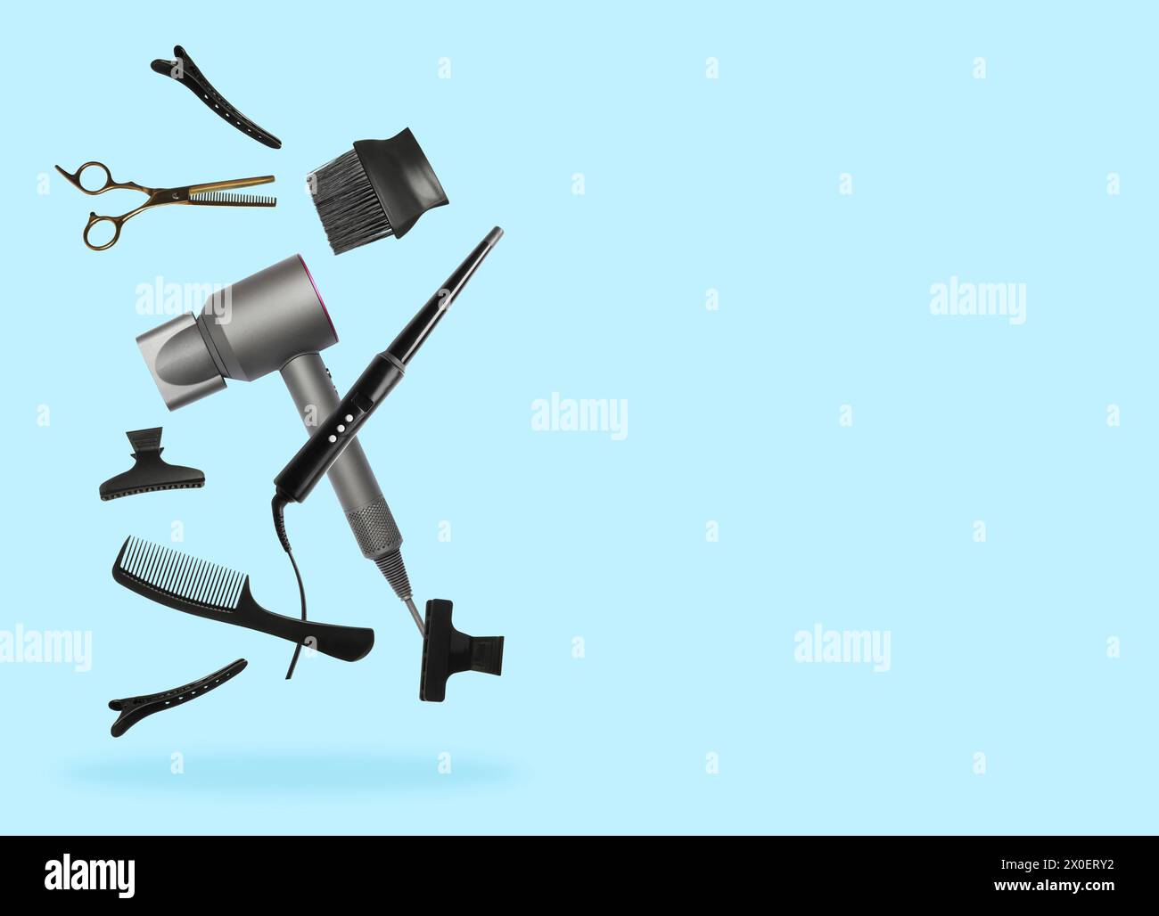 Professional hairdresser tools falling on light blue background, space ...