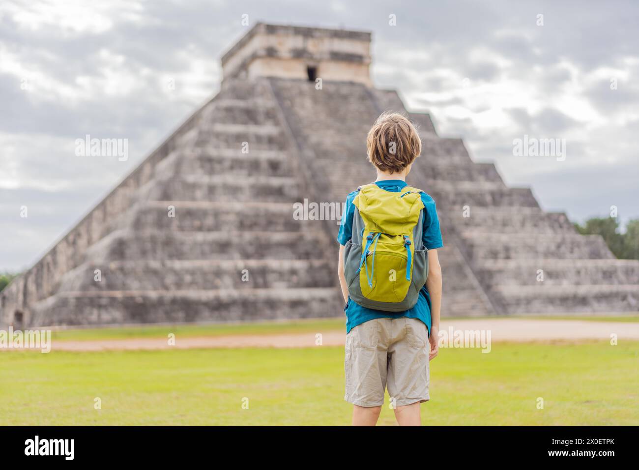 Boy traveler, tourists observing the old pyramid and temple of the ...