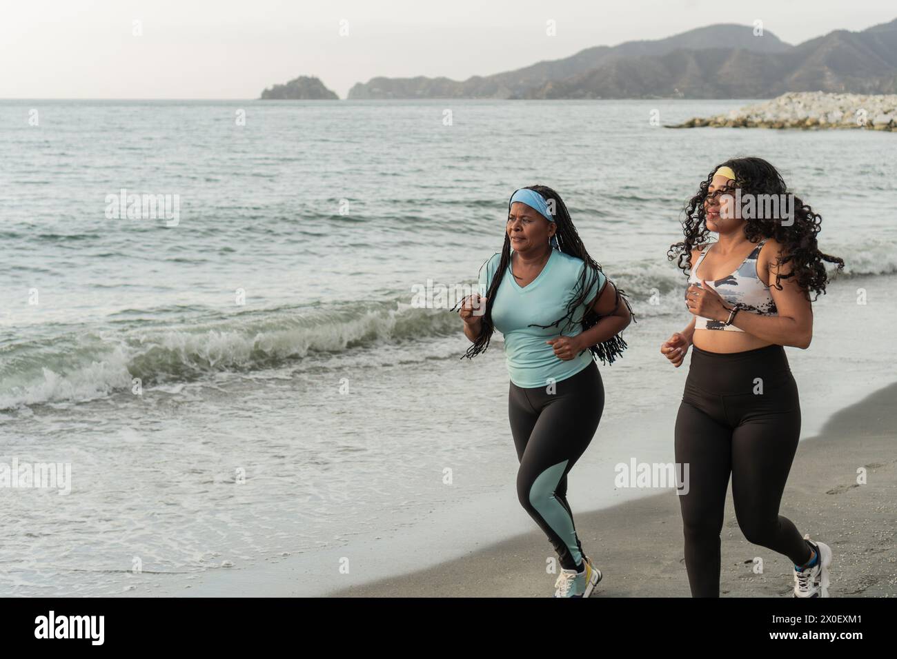 Women in workout attire jog together along the beach, enjoying the ...