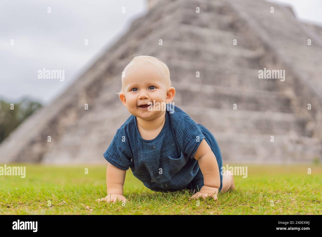 Baby traveler, tourists observing the old pyramid and temple of the ...