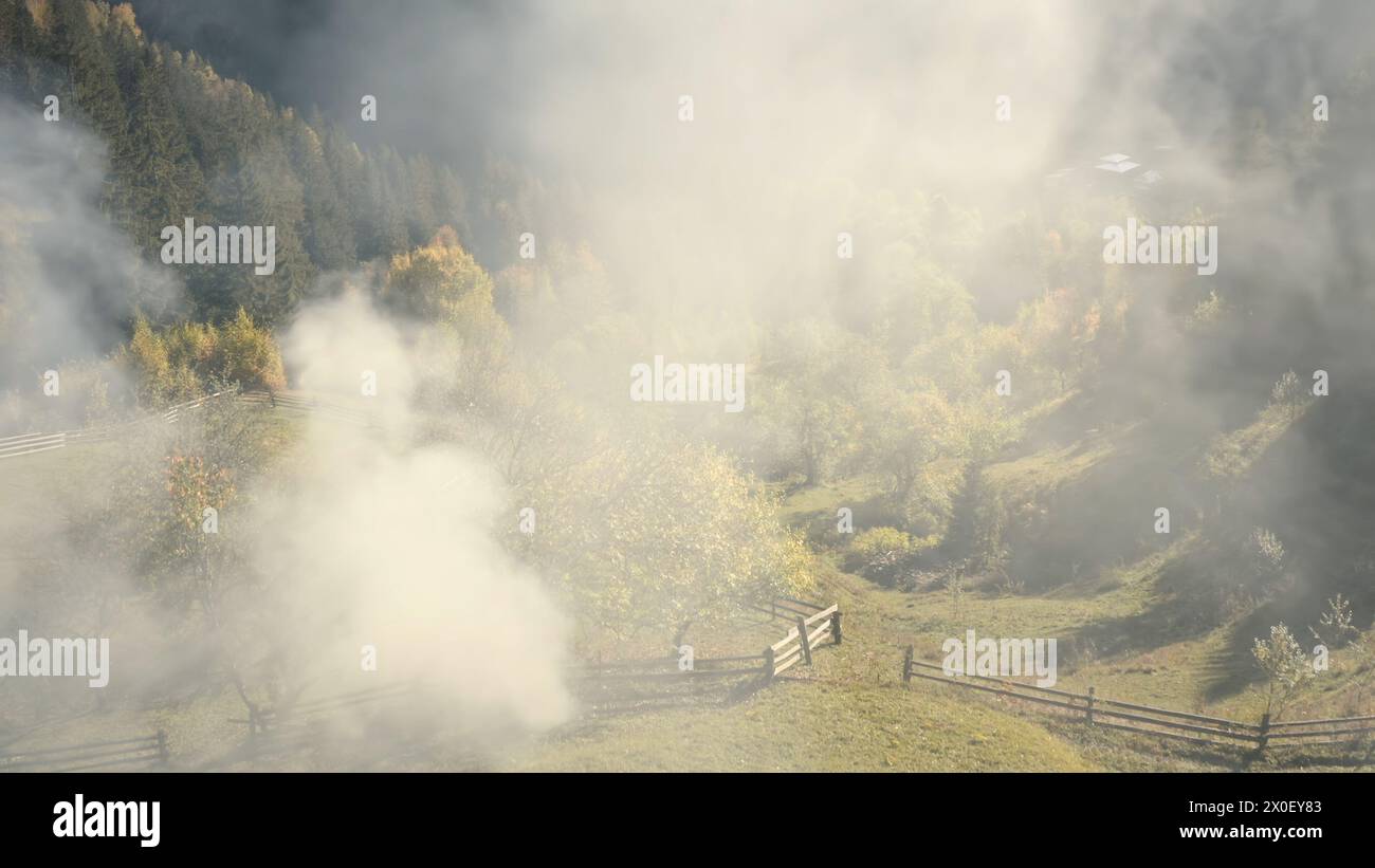 Aerial of thick smoke over mountain hills. Fir, leafy forest in smoky ...