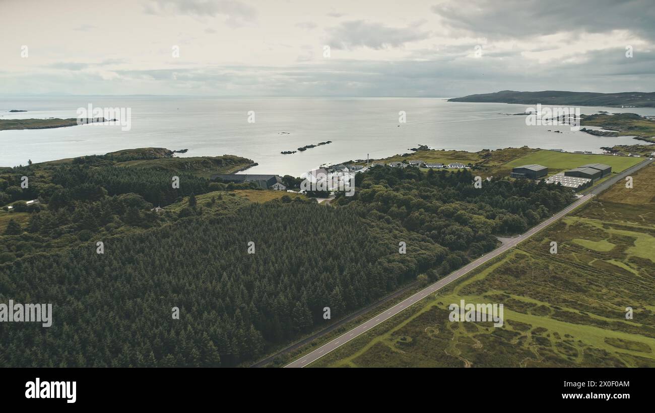 Whiskey distillery warehouse at sea bay. Green forest at seascape ...