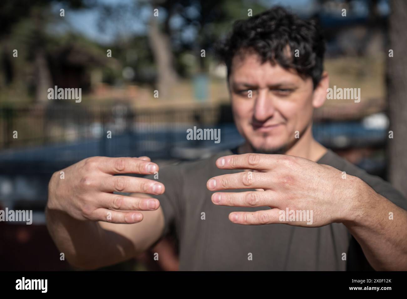 A middle-aged Caucasian man assumes the static posture of Tree Hugging ...