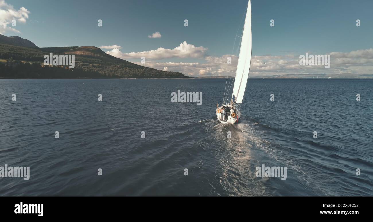 Racing yacht at ocean gulf of Brodick harbor aerial. Mountainous island ...