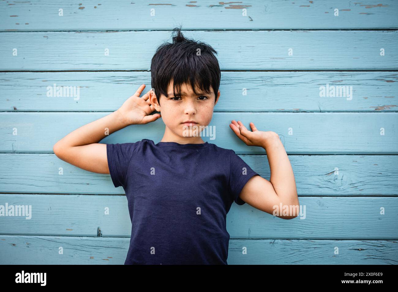 portrait of very serious child with short dark hair and a lot of ...
