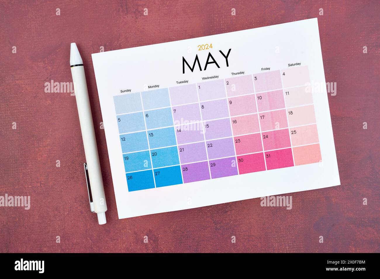 May 2024 calendar page and pen on red color retro background Stock ...