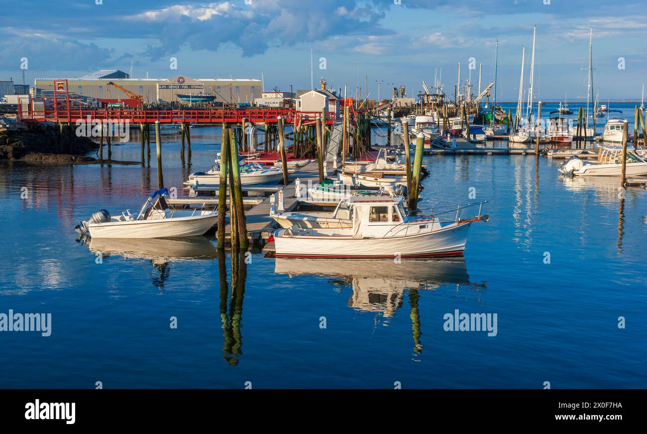 Boats docked at Landings Marina in Rockland Harbor, Maine, USA, with a ...