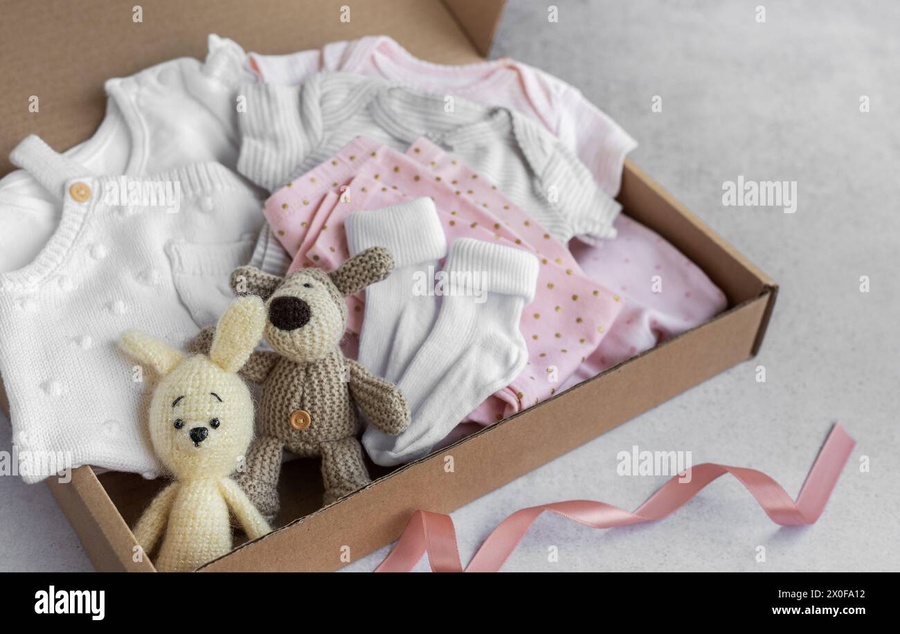 Baby and child clothes and knitted toys in carton box. Donation ...