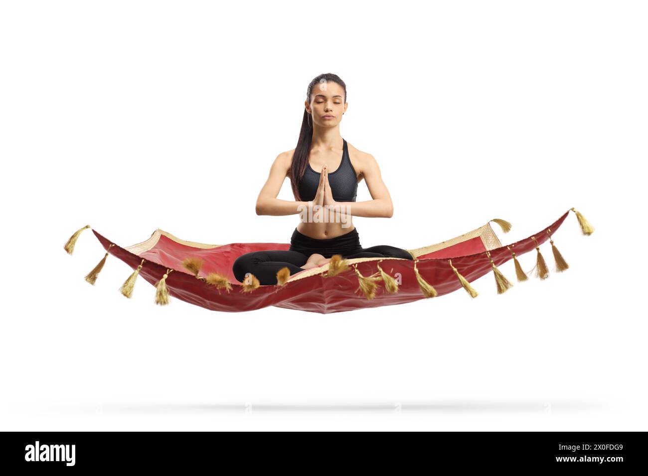 Young female in a meditation pose on a magic flying carpet isolated on ...