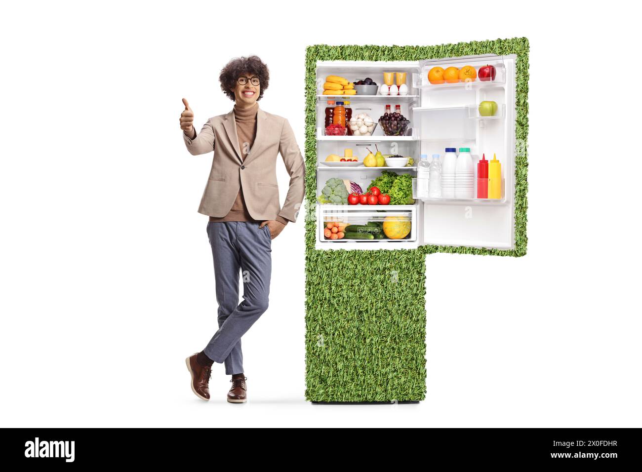 Young man gesturing thumbs up next to a green eco-friendly fridge with ...