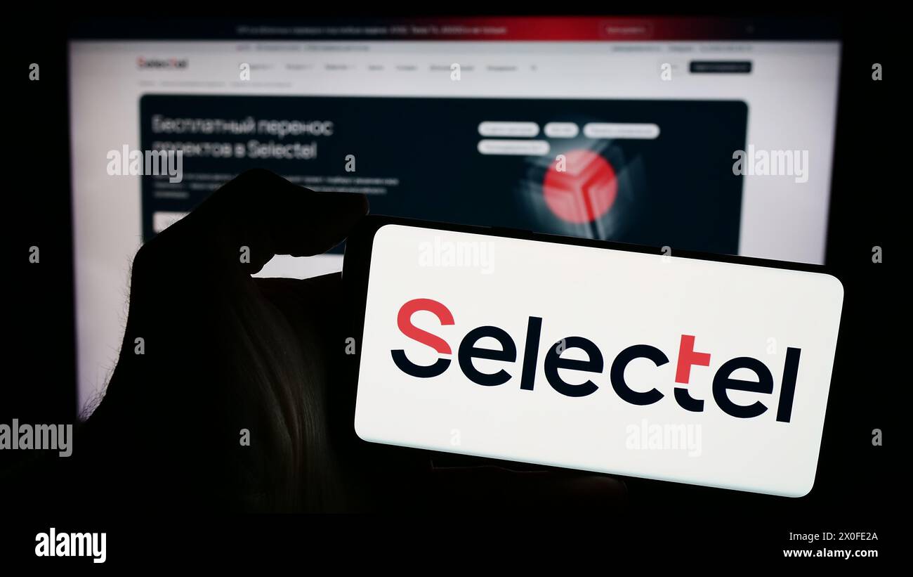 Person holding mobile phone with logo of Russia cloud infrastructure company Selectel Ltd. in ...